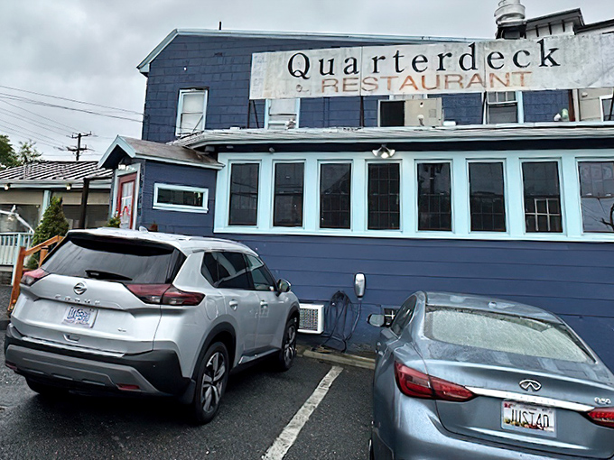 The navy blue exterior of Quarterdeck glows at dusk, a beacon for crab lovers hiding in plain sight along Arlington's streets.