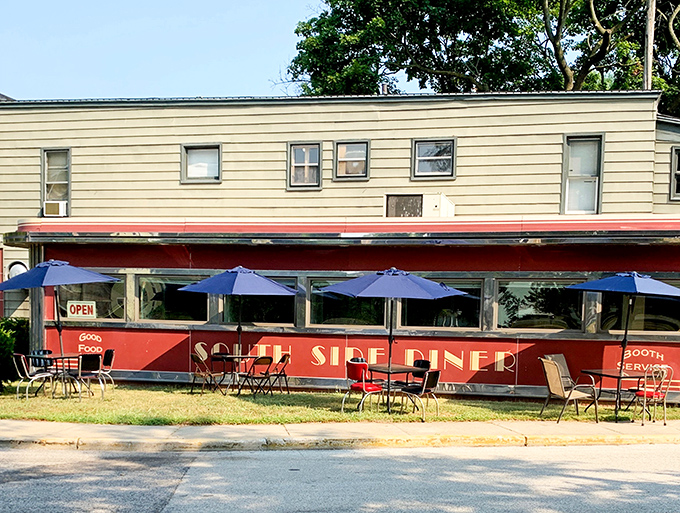 The classic red facade of South Side Soda Shop stands like a time capsule on Goshen's Main Street, complete with blue umbrellas that beckon hungry travelers to slow down and savor.