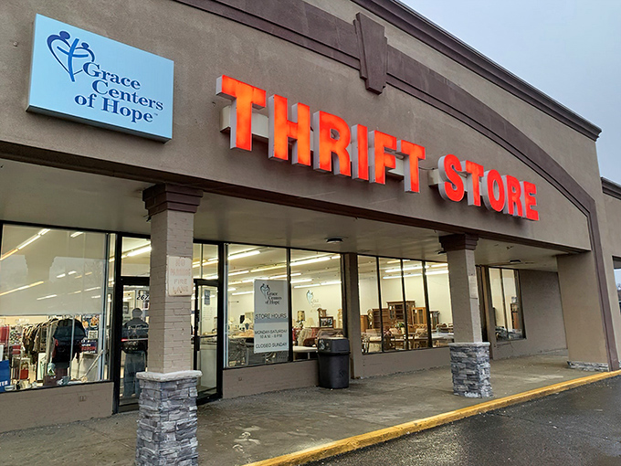 The bold red "THRIFT STORE" sign beckons like a lighthouse for bargain hunters. This unassuming exterior houses treasures waiting to be discovered.