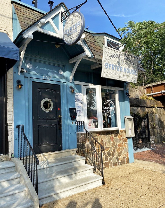 The blue facade of Trolley Square Oyster House beckons like a maritime mirage in urban Wilmington, promising seafood treasures behind that charming porthole door.