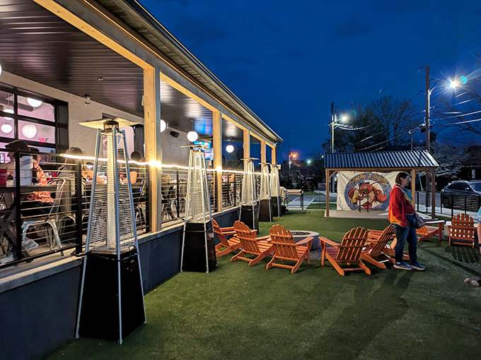 The evening glow transforms Pinchy's patio into a coastal retreat, complete with heat lamps and those iconic orange Adirondack chairs that practically whisper "relax and stay awhile."