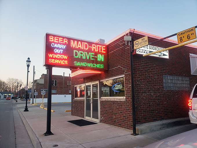 The neon beacon of Greenville! Maid-Rite's vintage sign promises three essential food groups: beer, sandwiches, and nostalgia&mdash;all available via drive-in window service.