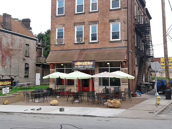The unassuming brick exterior of Showcase BBQ belies the culinary treasures within. Those patio tables have witnessed countless barbecue epiphanies.