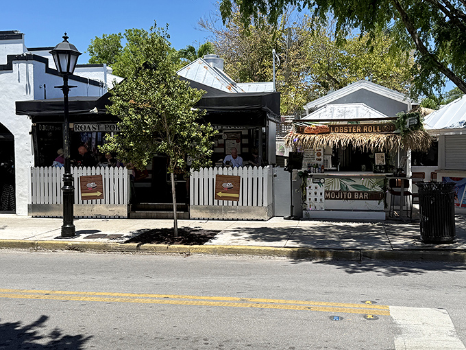 The white picket fence isn't keeping anyone out—it's practically inviting you into this slice of seafood heaven on Duval Street.