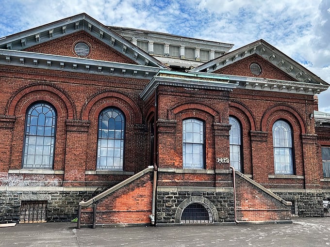 The majestic brick exterior of Housewerks stands like a Victorian time machine, its arched windows promising treasures within that modern buildings simply can't match.