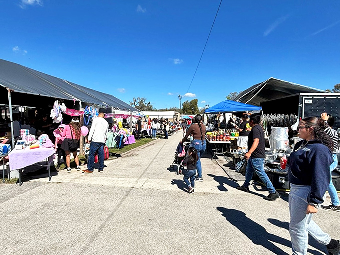 The main thoroughfare at Mi Pueblo buzzes with weekend energy as shoppers hunt for treasures under Florida's brilliant blue skies.