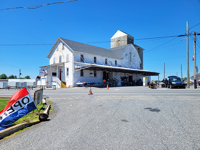 The iconic white clapboard building of Root's Old Mill stands like a beacon for treasure hunters, promising adventures in antiquing under that perfect Pennsylvania blue sky.