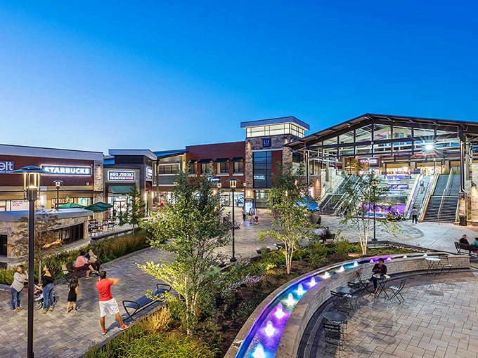 Twilight transforms Clarksburg Premium Outlets into a glowing retail paradise where shoppers drift between stores like treasure hunters on a mission.