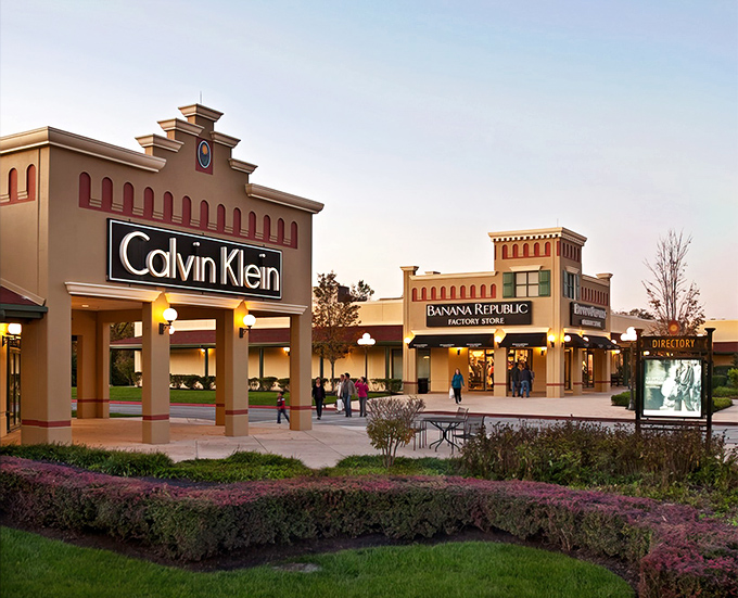 The retail promised land awaits! Calvin Klein and Banana Republic stand like sentinels at the entrance to Hagerstown Premium Outlets, beckoning bargain hunters with architectural flair.
