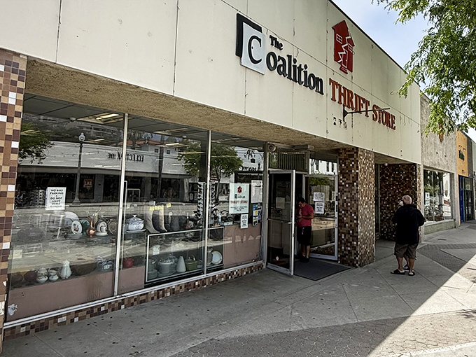 The iconic red house logo of Coalition Thrift Store beckons treasure hunters with a promise of adventures waiting inside those unassuming walls.