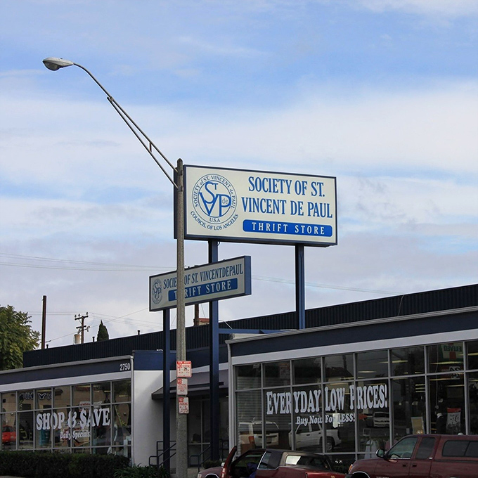 The blue and white storefront promises "Shop & Save" &ndash; not just a slogan but a sacred covenant between you and your wallet.