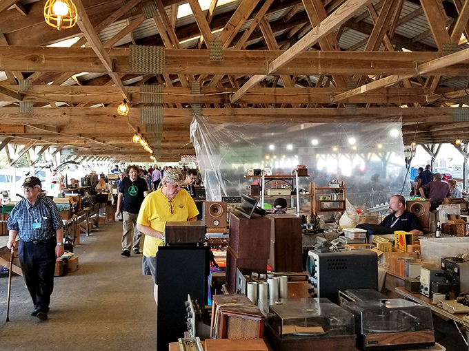 Wooden beams frame treasure hunters as they navigate aisles of history. The market's rustic architecture creates the perfect backdrop for discovery.