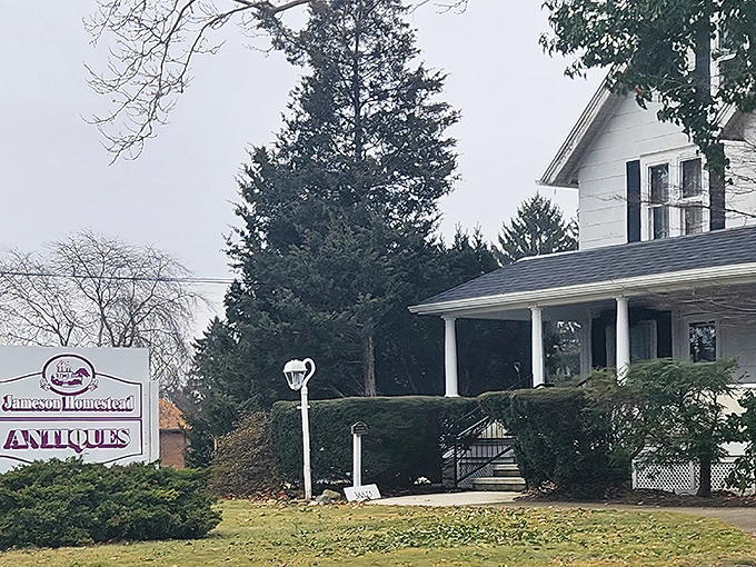 The classic white farmhouse exterior of Jameson Homestead Antiques stands like a time capsule waiting to be opened, complete with inviting porch and vintage charm.