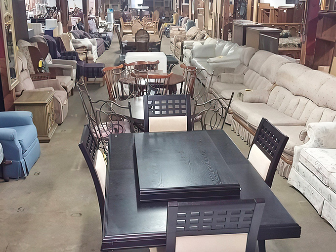 Row after row of solid wood furniture stretches into the distance, each piece silently whispering stories of dinners, conversations, and lives once lived.