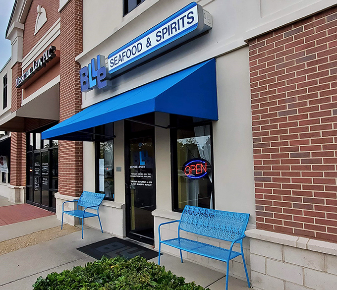 The unassuming blue awning hides culinary treasures within, like Superman disguised as Clark Kent in a strip mall.