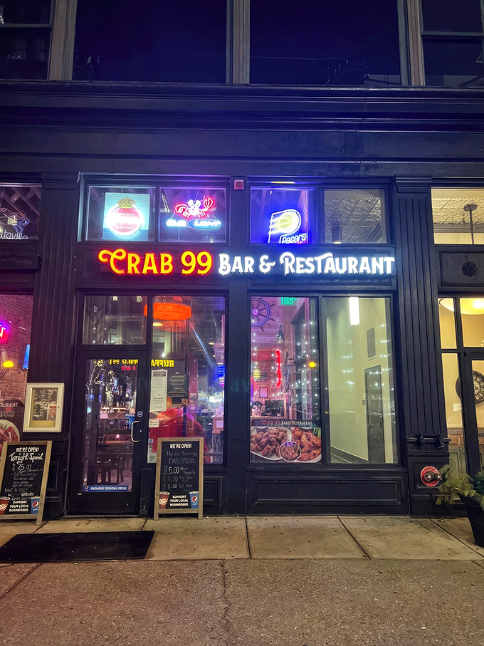The glowing red "Crab 99" sign beckons like a lighthouse for seafood lovers, promising treasures from the sea in downtown Indianapolis.