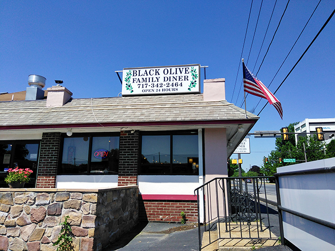 The blue neon glow of Black Olive Family Diner beckons hungry travelers like a lighthouse for the famished. Classic diner architecture with a modern twist. 