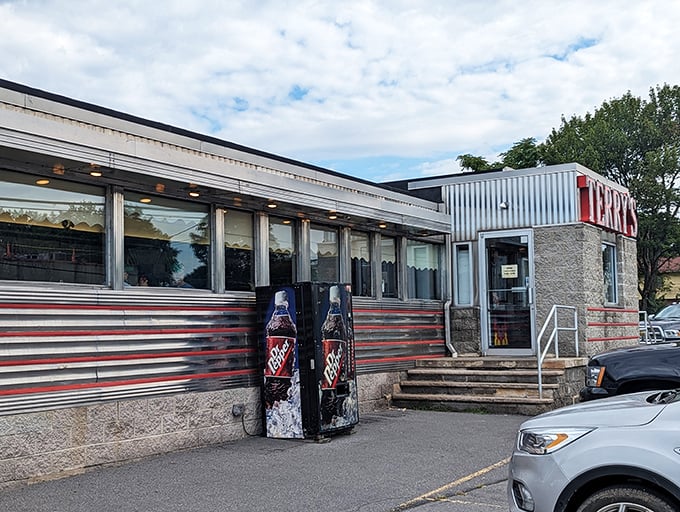 The classic stainless steel exterior of Terry's Diner gleams like a time machine to the golden age of roadside Americana. Those vintage soda machines aren't just for show!