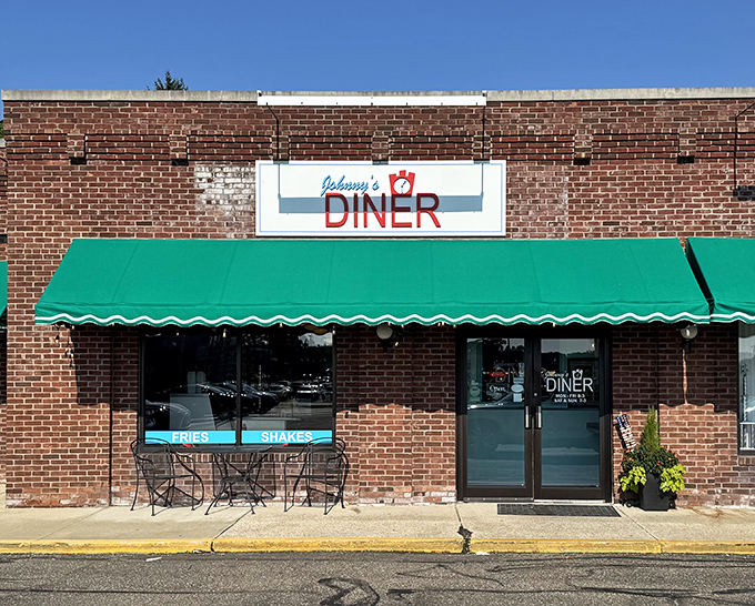 The unassuming brick exterior of Johnny's Diner, with its cheerful green awning, promises nostalgic comfort like a warm hug from your favorite aunt.