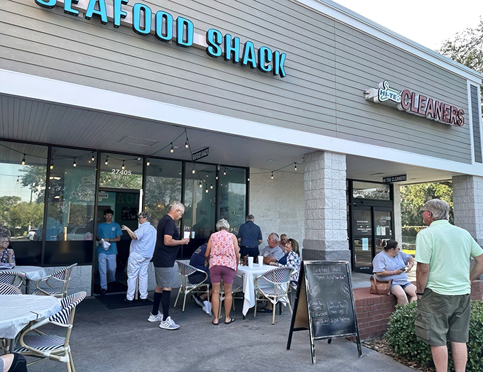 The bright turquoise "SEAFOOD SHACK" sign beckons like a coastal lighthouse, promising maritime treasures within. Those outdoor tables aren't just furniture&mdash;they're stages for impending seafood euphoria.
