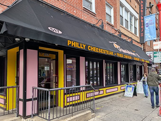 The unmistakable black awning with bold yellow lettering announces your arrival at cheesesteak paradise. South Street's pink and yellow beacon beckons hungry pilgrims.