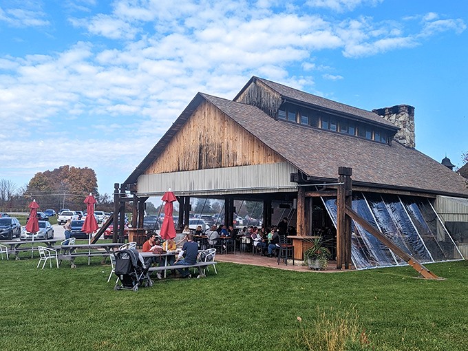The rustic barn exterior of Sarah's Vineyard welcomes visitors with its weathered wood charm and inviting outdoor seating&mdash;Napa Valley spirit with heartland hospitality.
