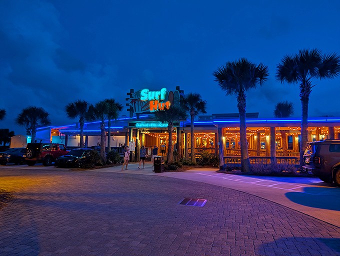 The iconic Surf Hut sign welcomes beach-goers with a promise of seafood paradise. Palm trees stand guard like culinary sentinels.