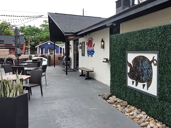 The inviting patio at Pig Floyd's welcomes barbecue pilgrims with playful pig artwork and comfortable outdoor seating&mdash;a carnivore's sanctuary in Orlando's Mills 50 district.