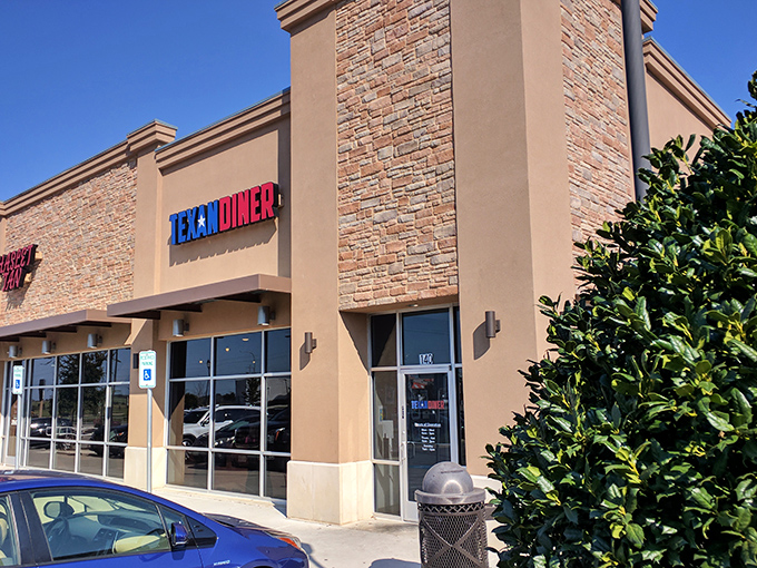 The iconic blue and red Texan Diner sign beckons from its stone facade like a patriotic beacon for hungry travelers.