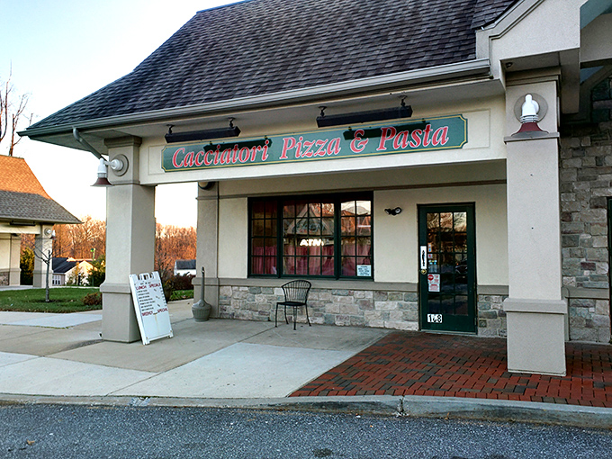 The welcoming storefront of Cacciatori Pizza & Pasta beckons with its warm brick facade and inviting entrance, promising Italian comfort within.