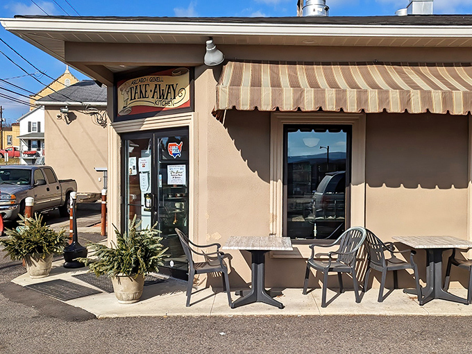 The glowing "TAKE-AWAY KITCHEN" sign at Arcaro and Genell beckons like a lighthouse for hungry travelers in Old Forge's pizza paradise.