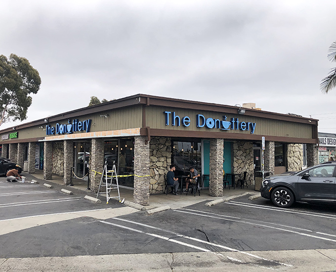The blue neon sign beckons like a lighthouse for the sweet-toothed, promising donut nirvana behind those unassuming doors.