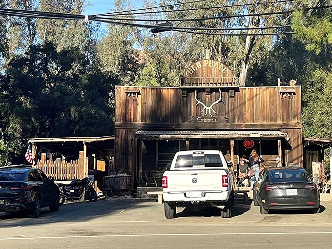 The Old Place stands like a time capsule in Agoura Hills, its weathered wood and stone facade promising culinary adventures that cowboys of yesteryear could only dream about.