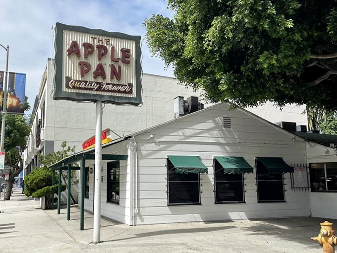 The unassuming white exterior of The Apple Pan stands like a time capsule on Pico Boulevard, its vintage sign promising "Quality Forever" – a bold claim they've been backing up since 1947.