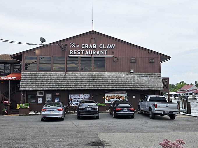 The Crab Claw stands proudly over the water like a sentinel of seafood, its weathered wooden frame promising maritime delights within those red-trimmed walls.