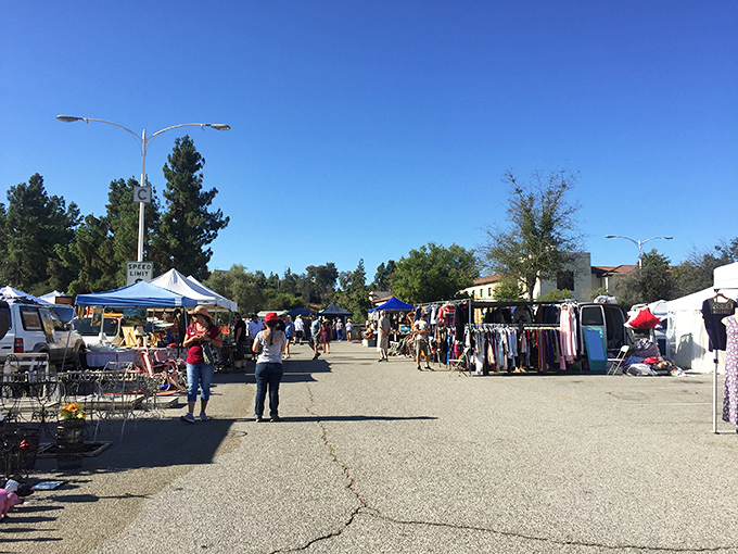 Treasure hunters navigate the sun-drenched aisles of Topanga Vintage Market, where each white tent houses potential discoveries waiting to be unearthed.