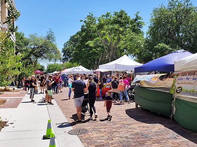 Sunshine, brick pathways, and white tents create the perfect Saturday morning backdrop where strangers become friends over fresh produce and artisanal treats.