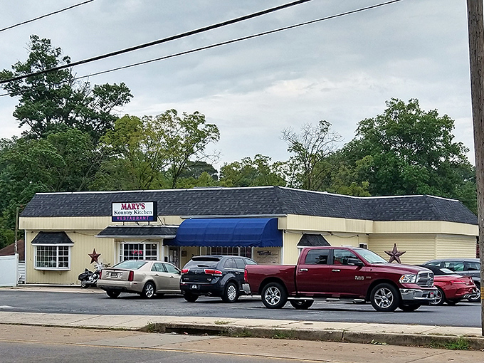 The unassuming yellow exterior of Mary's Kountry Kitchen, complete with rustic star and motorcycle, promises authentic comfort without pretension.