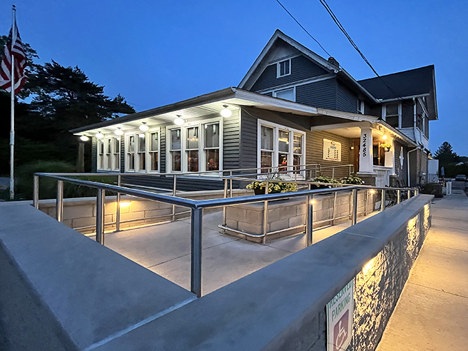 Jake's On Lake glows with welcoming warmth at dusk, its charming gray exterior and accessible entrance promising comfort before you even step inside.