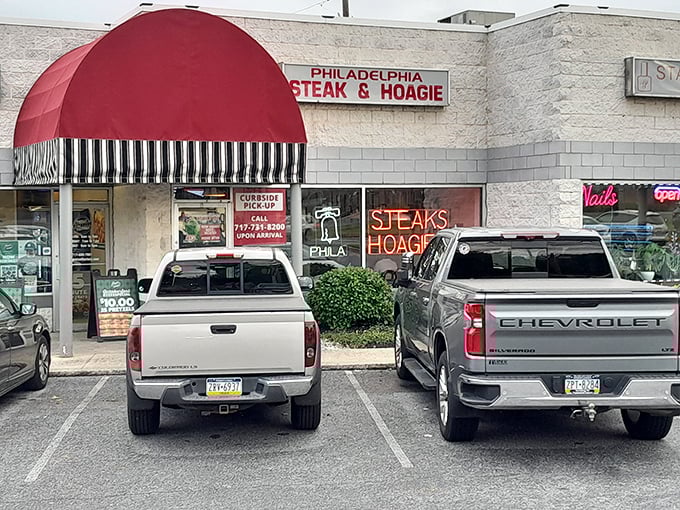 The iconic red awning beckons like a culinary lighthouse, promising authentic Philadelphia flavors in the heart of Camp Hill.