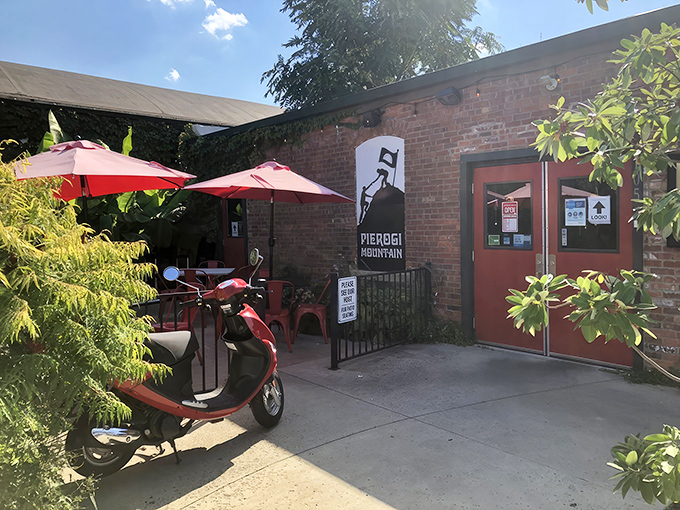 The unassuming brick exterior of Pierogi Mountain beckons with vibrant red umbrellas and a promise of Eastern European comfort food paradise.