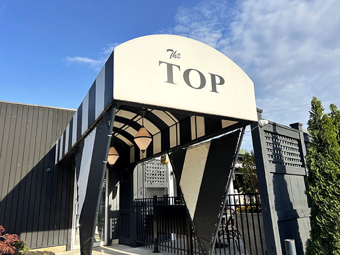 The iconic entrance to The Top Steakhouse stands like a mid-century modern beacon for carnivores, promising meaty delights within its hallowed walls.
