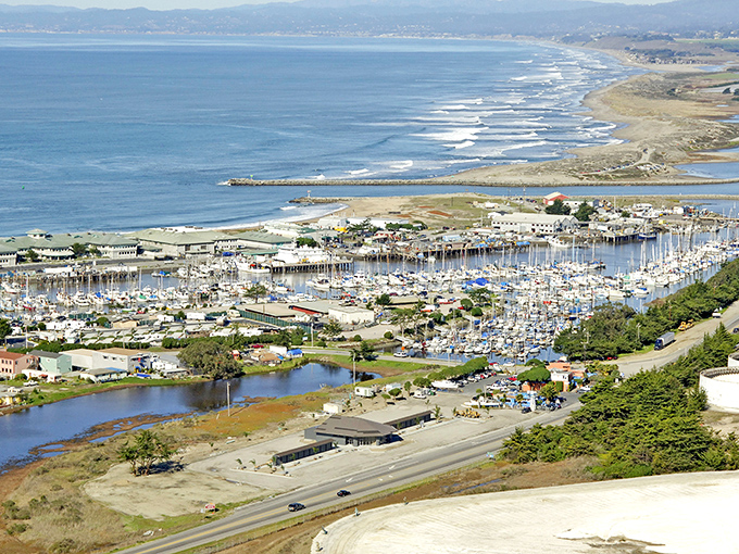 A bird's-eye view of paradise! Moss Landing's harbor nestles between farmland and ocean, where boats bob like colorful toys in nature's perfect playground.