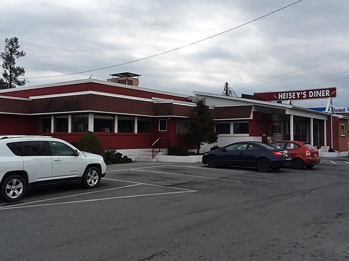 The unassuming red exterior of Heisey's Diner stands like a beacon of hope for hungry travelers. No pretension, just the promise of honest food inside.