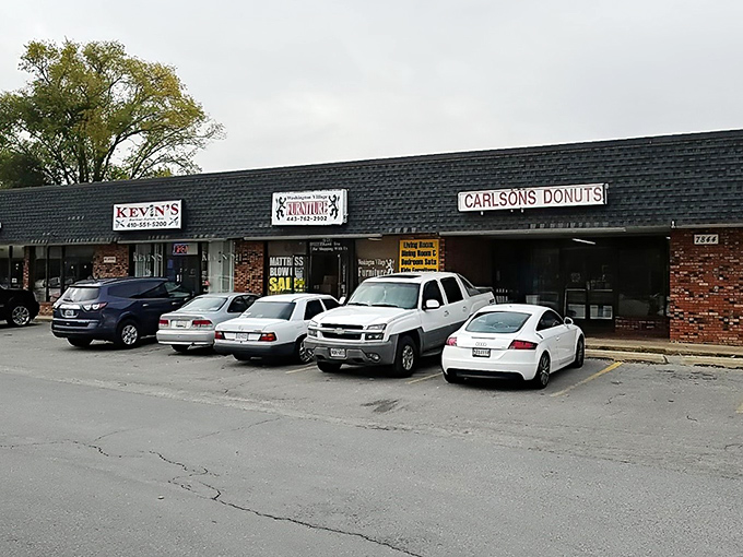 The unassuming brick facade of Carlson's Donuts stands like a beacon of sweetness among the strip mall surroundings. No frills, just donut thrills.