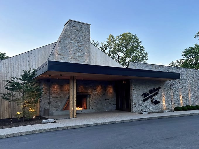The stone facade of Village Supper Club stands like a modern castle of cuisine, welcoming hungry travelers with its distinctive peaked roof and warm lighting.