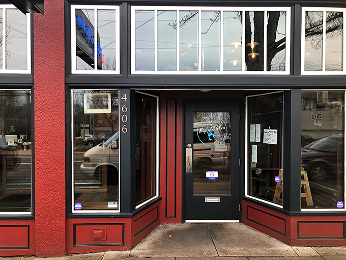 The bright red exterior of Big's Chicken welcomes hungry visitors with wooden picnic tables and cheerful orange umbrellas—Portland's version of a Southern front porch.