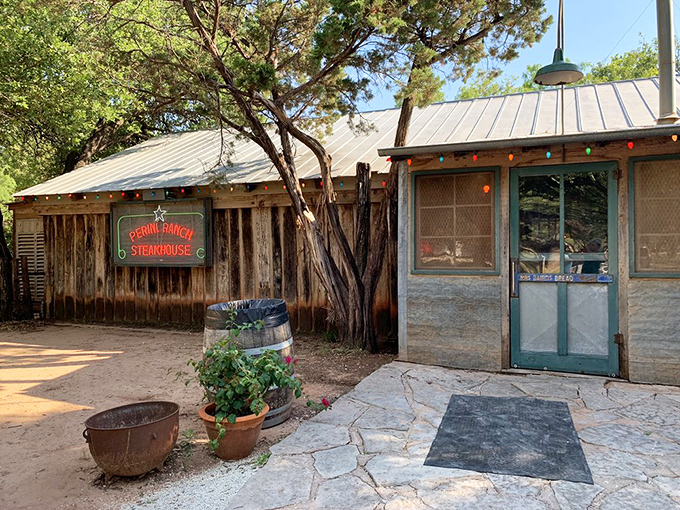 The rustic wooden exterior of Perini Ranch Steakhouse beckons like an old friend, complete with colorful string lights promising good times and better meals ahead.