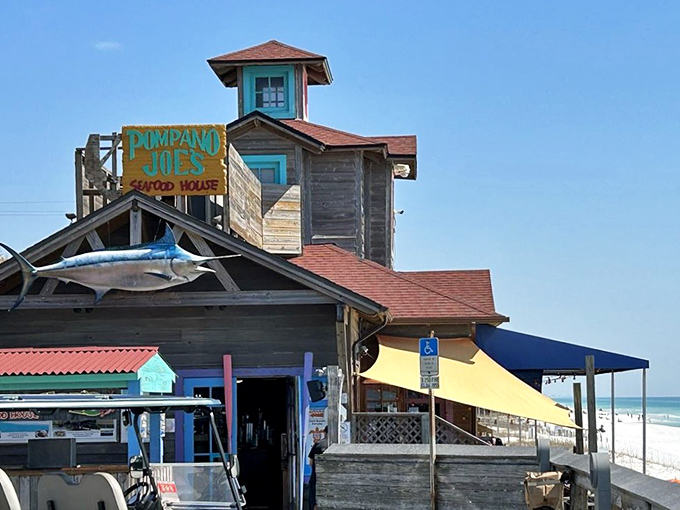 The weathered wooden exterior of Pompano Joe's, complete with its iconic watchtower and mounted marlin, promises seafood authenticity before you even step inside.