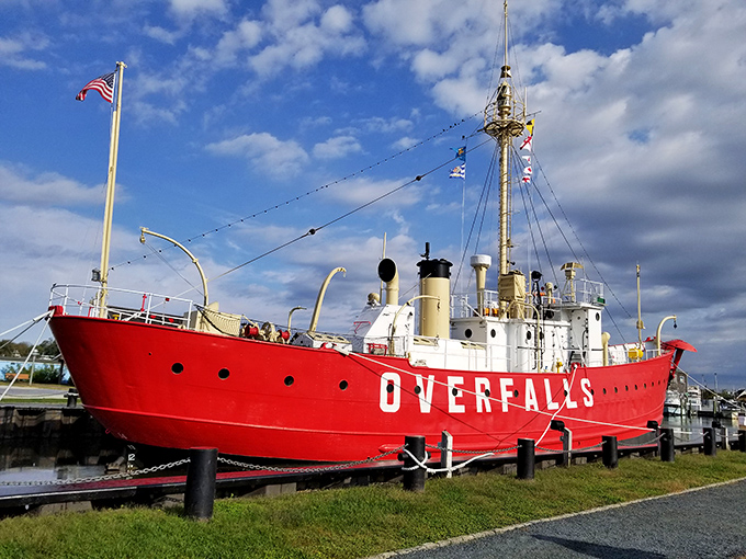 The Overfalls stands proudly along Lewes' Canalfront Park, its crimson hull practically shouting "Look at me!" to passersby enjoying their coastal stroll.